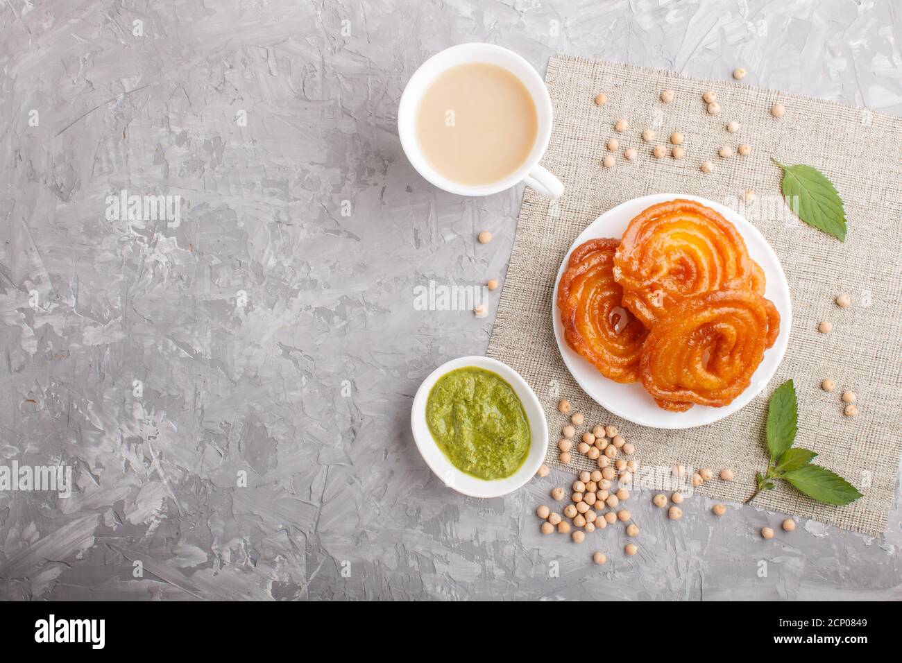 traditional indian candy jalebi in white plate with mint chutney on a ...