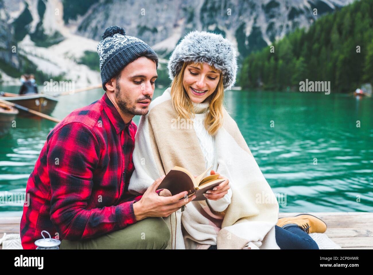 Beautiful couple of young adults visiting an alpine lake at Braies ...