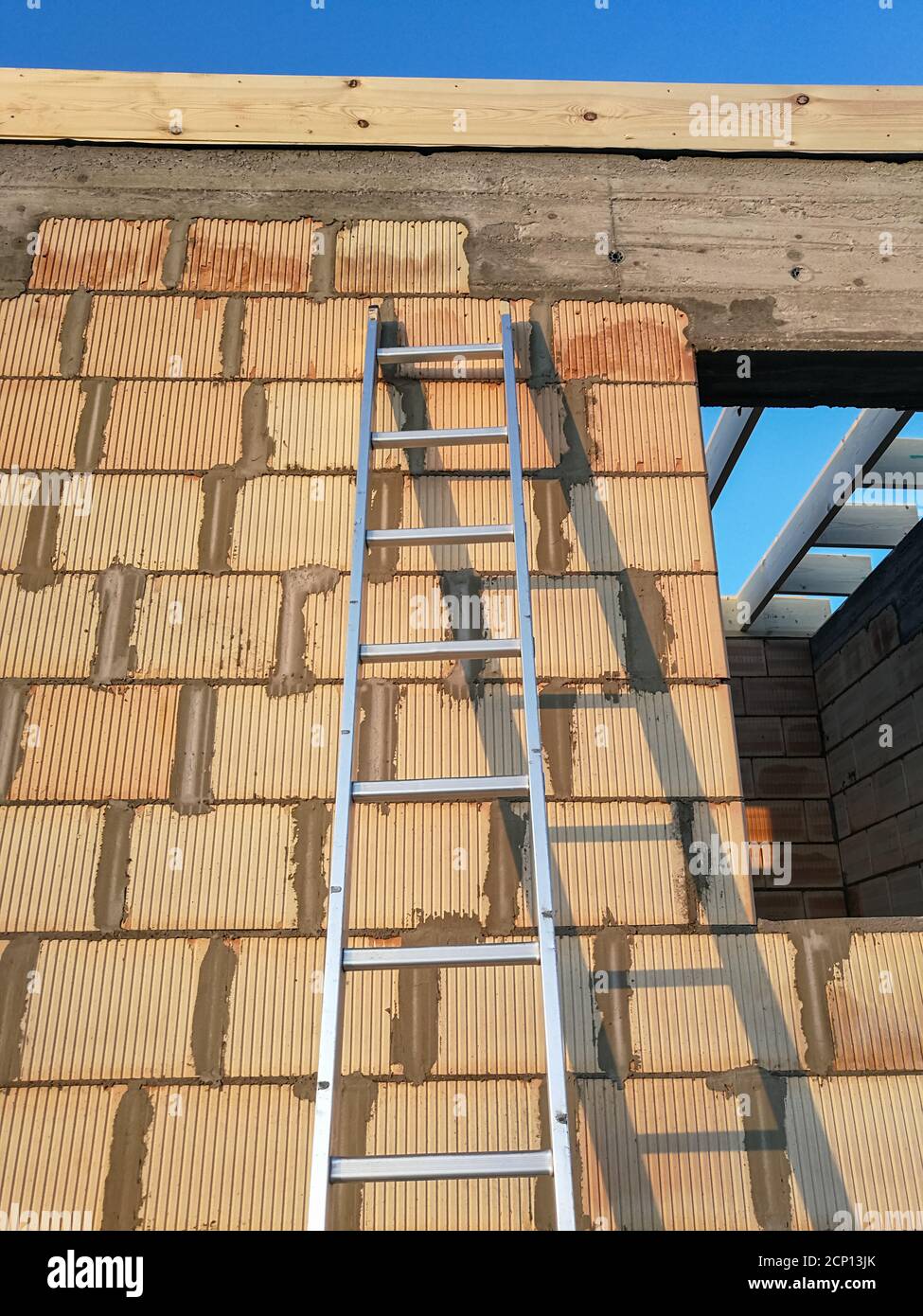 Aluminium ladders close to ceramic brick wall outdoor in construction ...