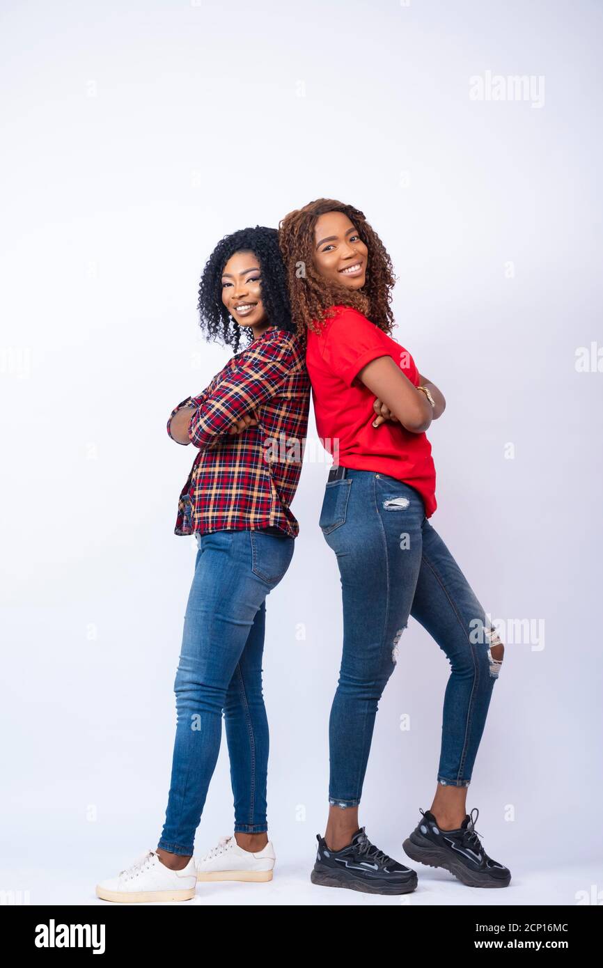 portrait of two beautiful african ladies standing back to back with ...