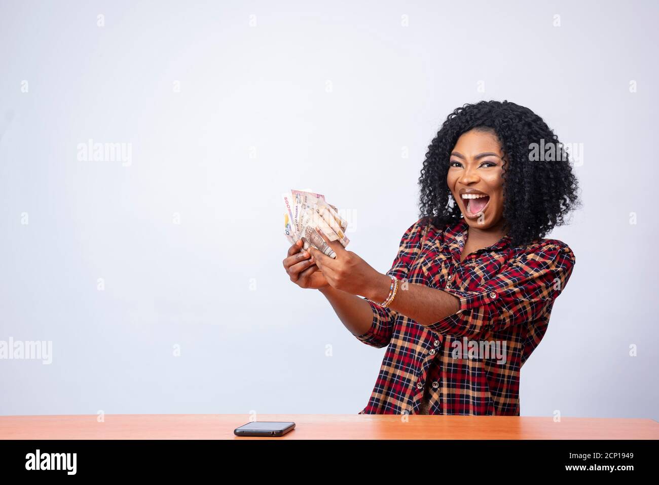 beautiful african lady holding some cash feeling excited and happy ...