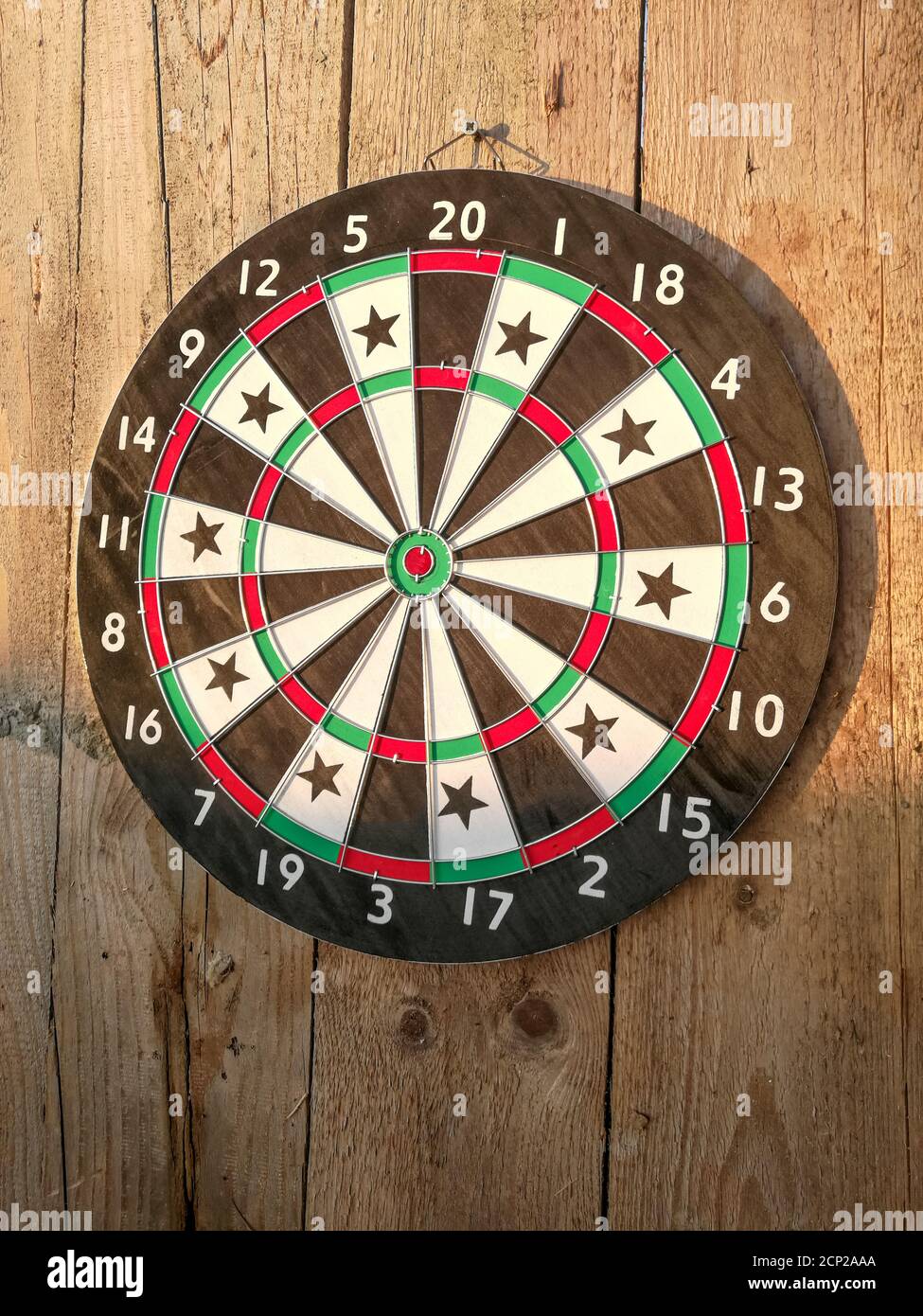 Dart wooden target hanged on the wall ready to play. Leisure activity ...