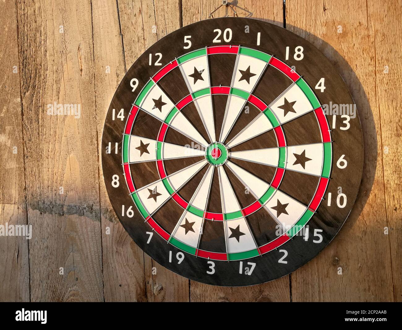 Dart wooden target hanged on the wall ready to play. Leisure activity ...