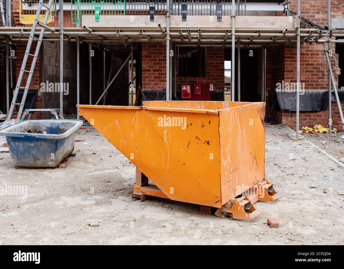 Combi Forklift Tipping Skip on construction site in front of new house ...