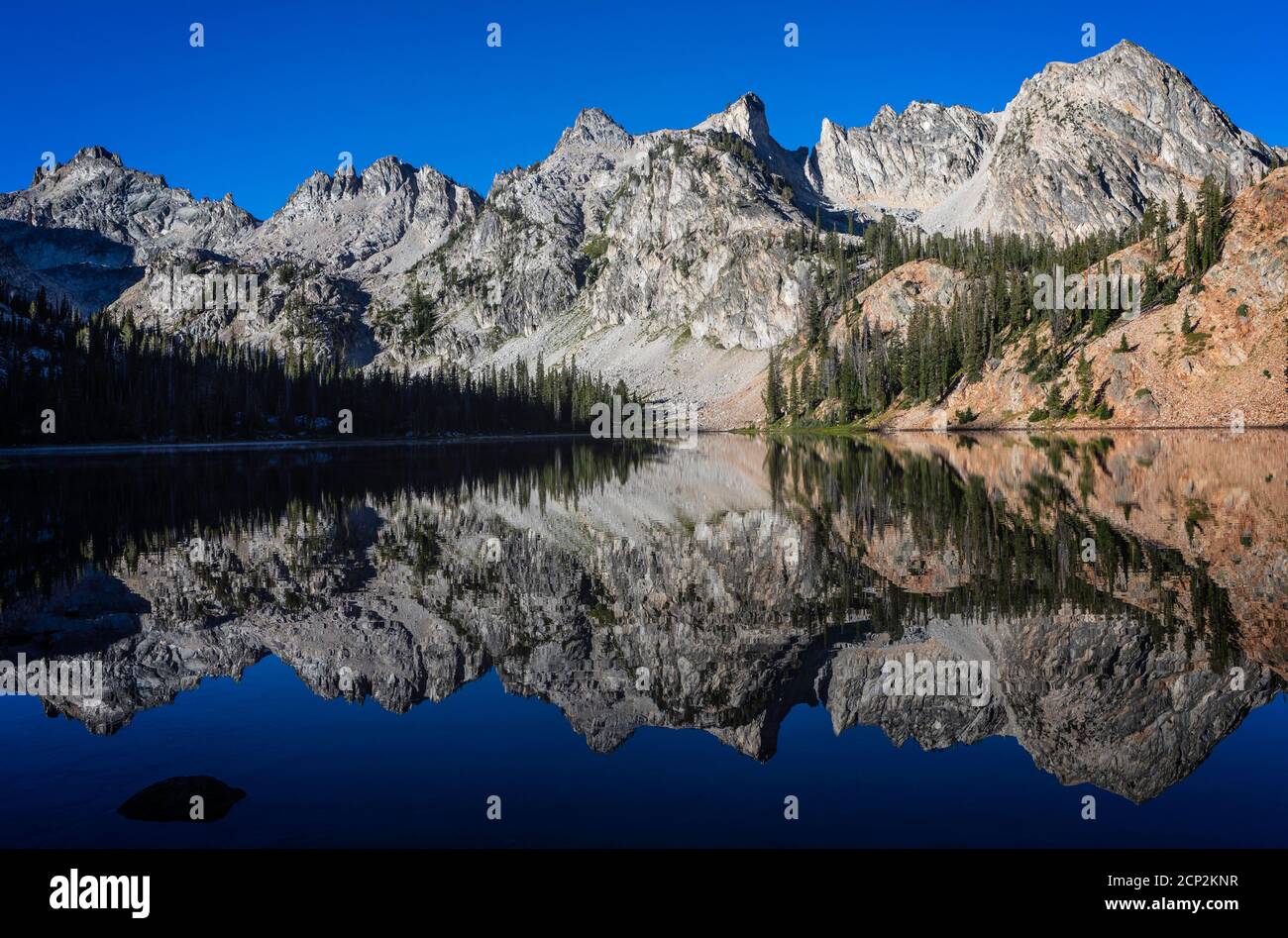 Alice Lake reflects the surrounding peaks under a blue sky, Sawtooth ...