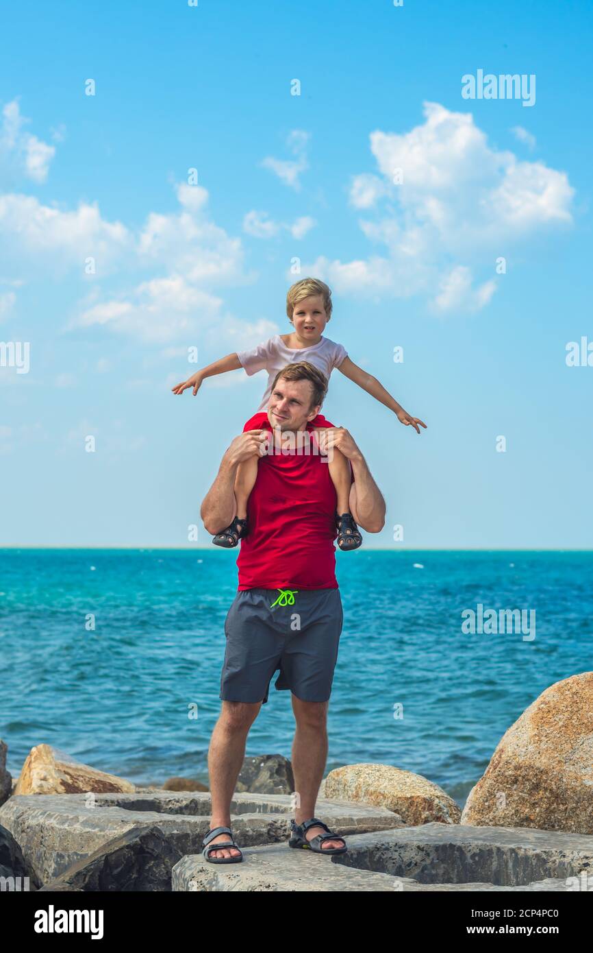 Happy smile father hugs holds on shoulders son boy male child stand ...