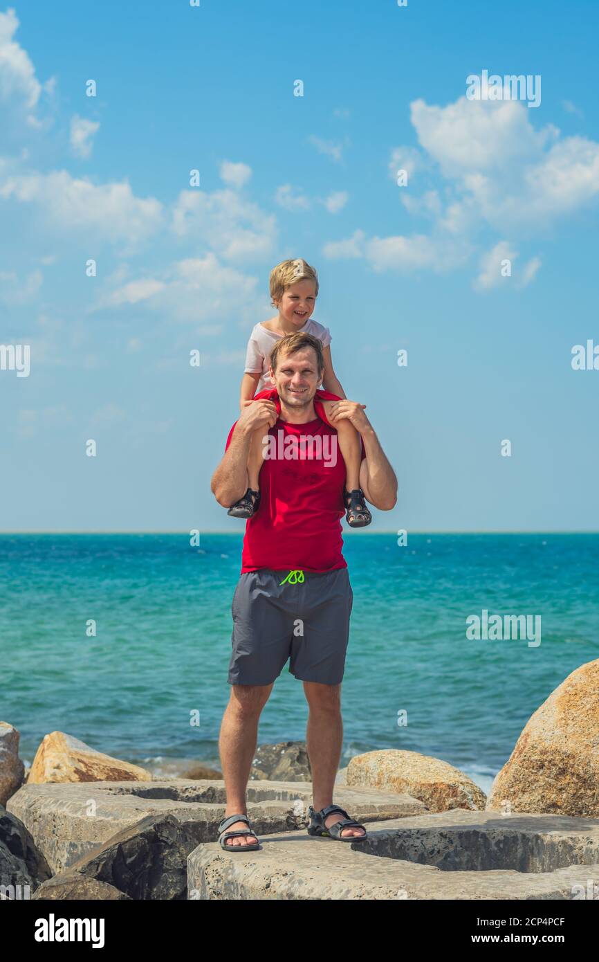 Happy smile father hugs holds on shoulders boy male child stand blue ...