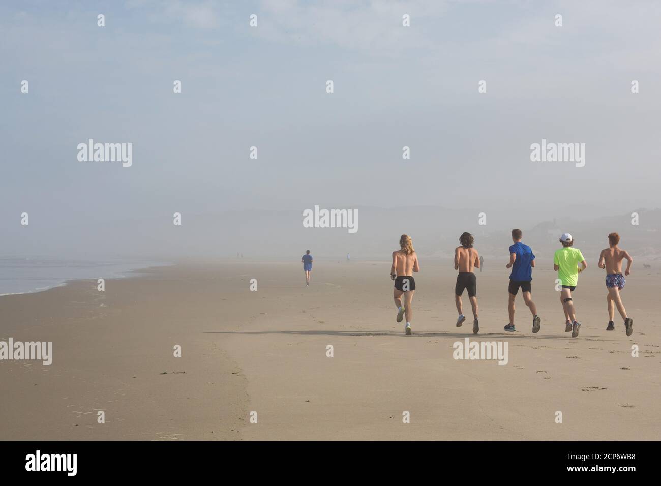 A group of teenage boys running together on a beach Stock Photo - Alamy