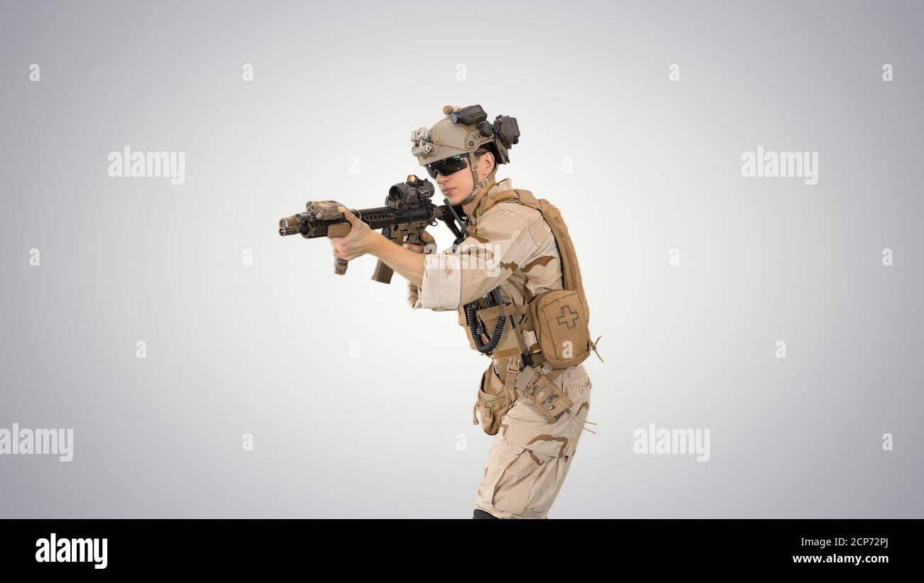Soldier aiming with an assault rifle on gradient background Stock Photo ...