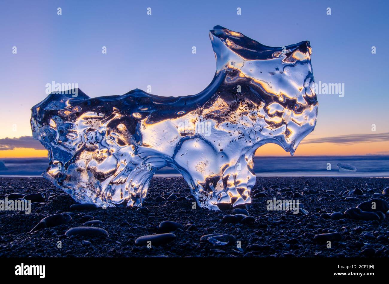 Iceberg shaped like dog on rocky sandy beach Stock Photo - Alamy