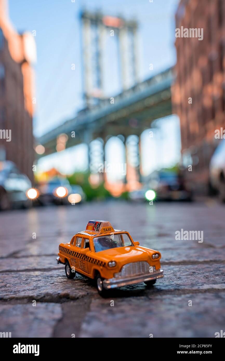 Vertical shot of a classic yellow taxi toy cab on a blurred background ...