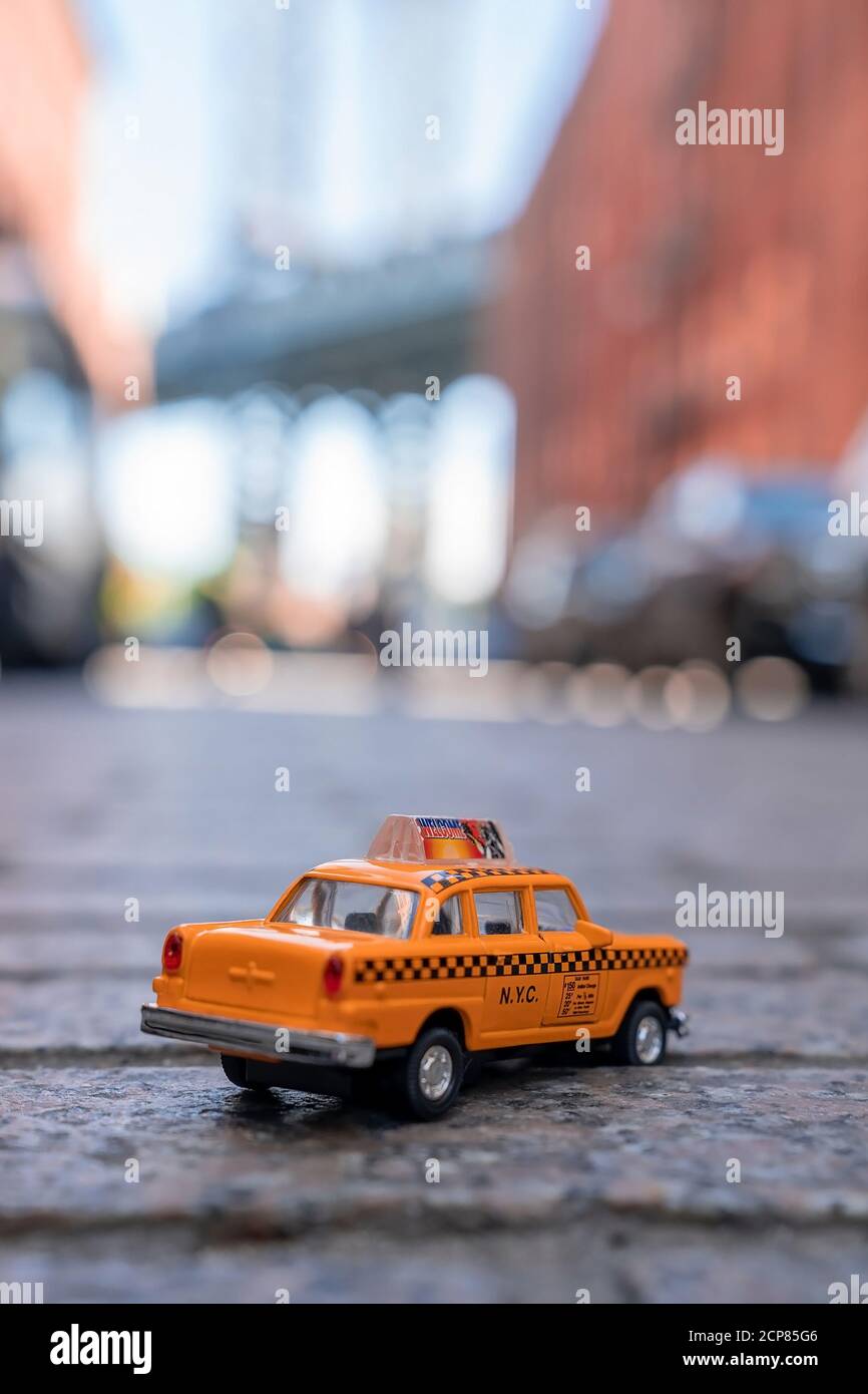 Vertical shot of a classic yellow taxi toy cab on a blurred background ...