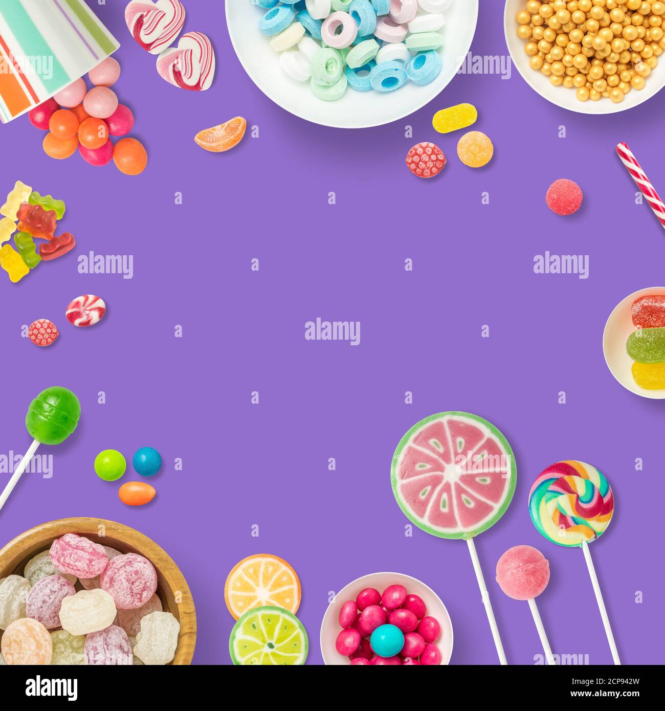 Candies, chocolates and lollipops on a purple background with copy ...