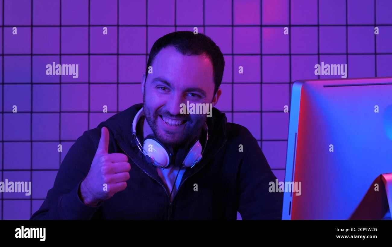 Joyful gamer guy playing video games on computer and showing thu Stock ...