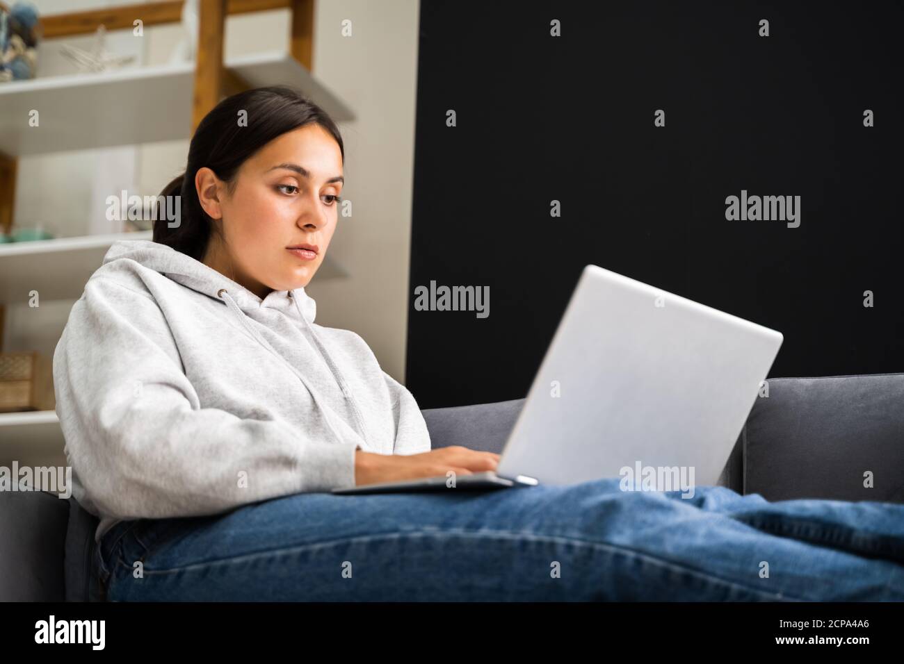 Women Using Computer Laptop On Couch Or Sofa Stock Photo - Alamy