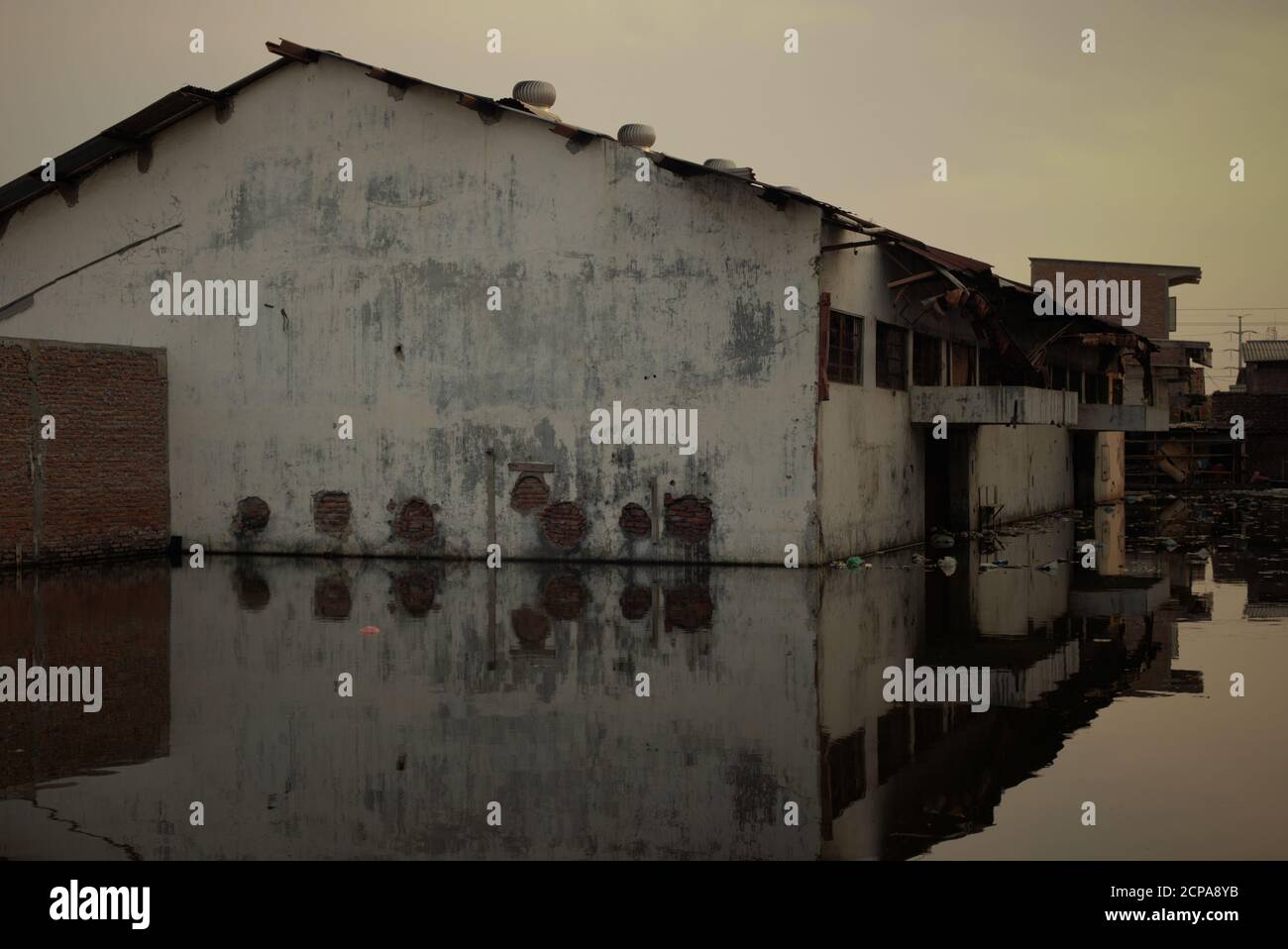 Submerged warehouse buildings on a coastal area suffering from land ...