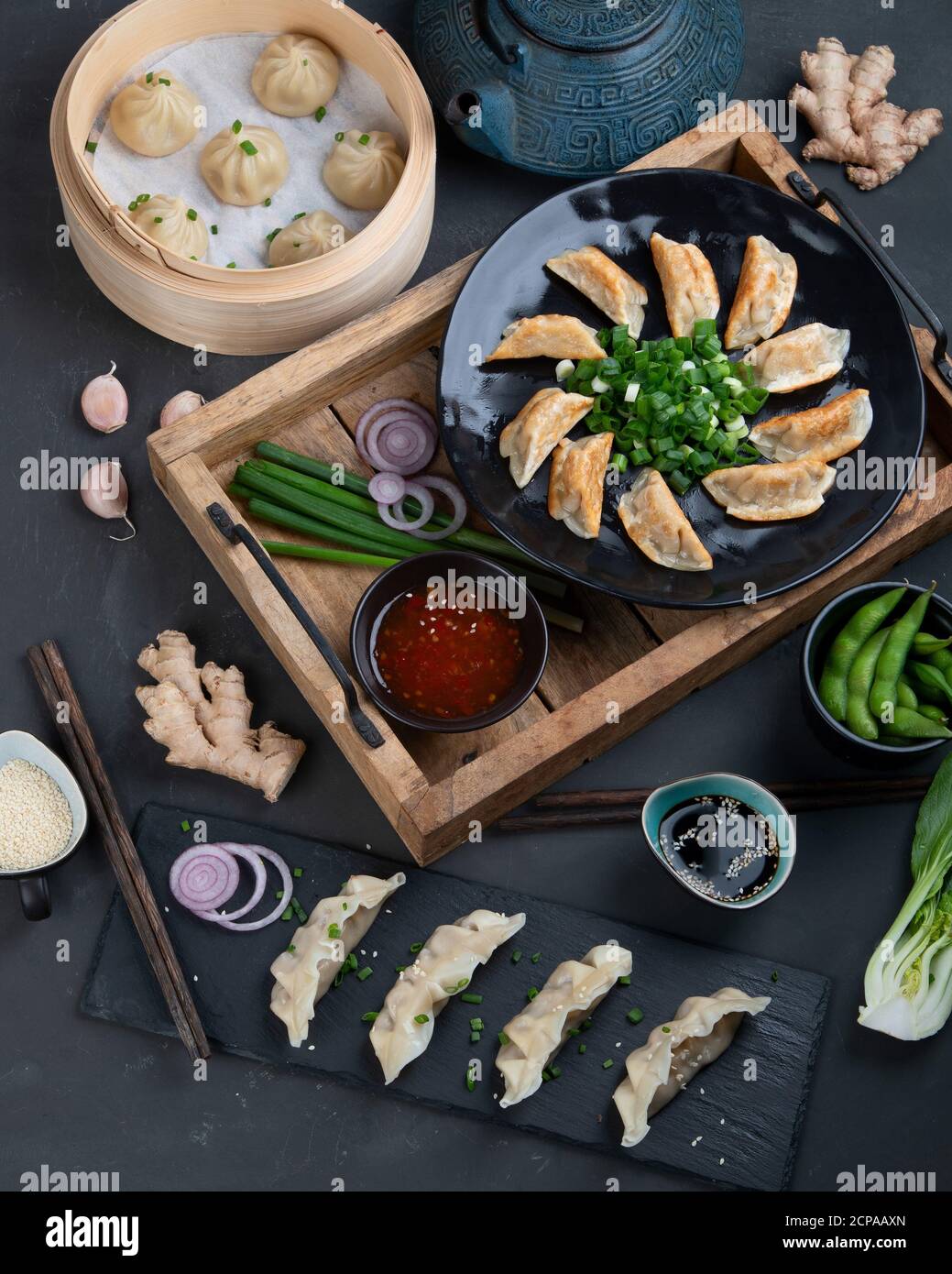 Asian dumplings set with variety of sauces and vegatables. Top view ...