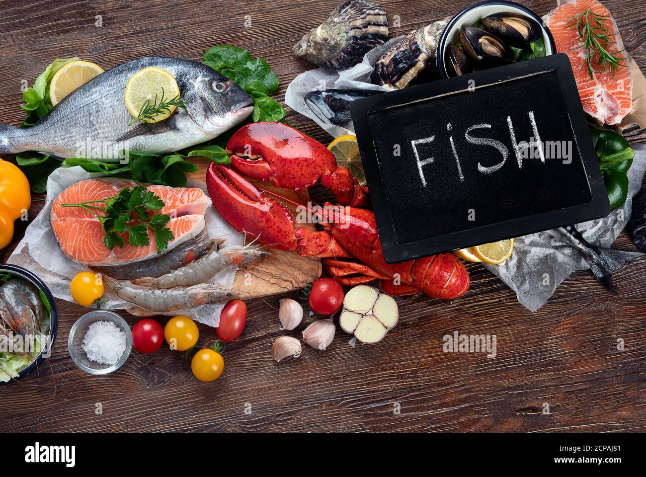 Fresh fish and seafood with herbs, spices and vegetables on rustic ...
