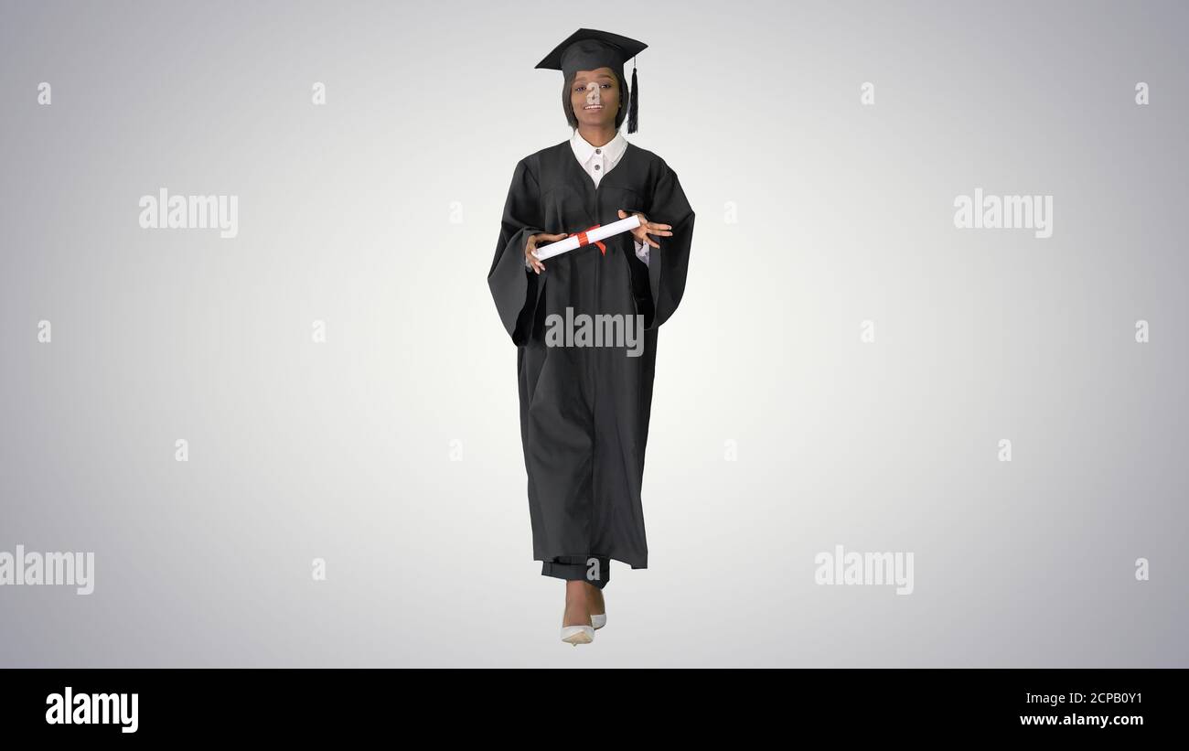 Young african graduate student walking and laughing on gradient Stock ...