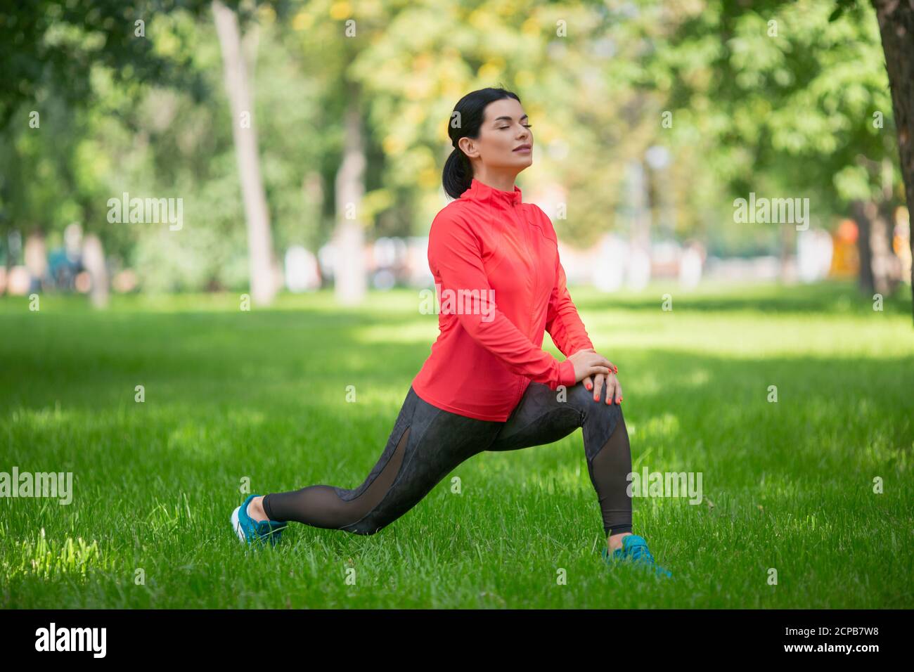 Outdoor workout. Woman doing exercises for legs in city park. Healthy ...