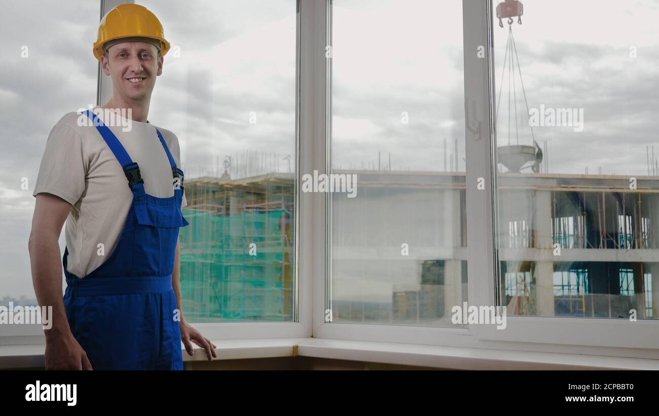 Smiling builder in the already built house. Construction site Stock ...