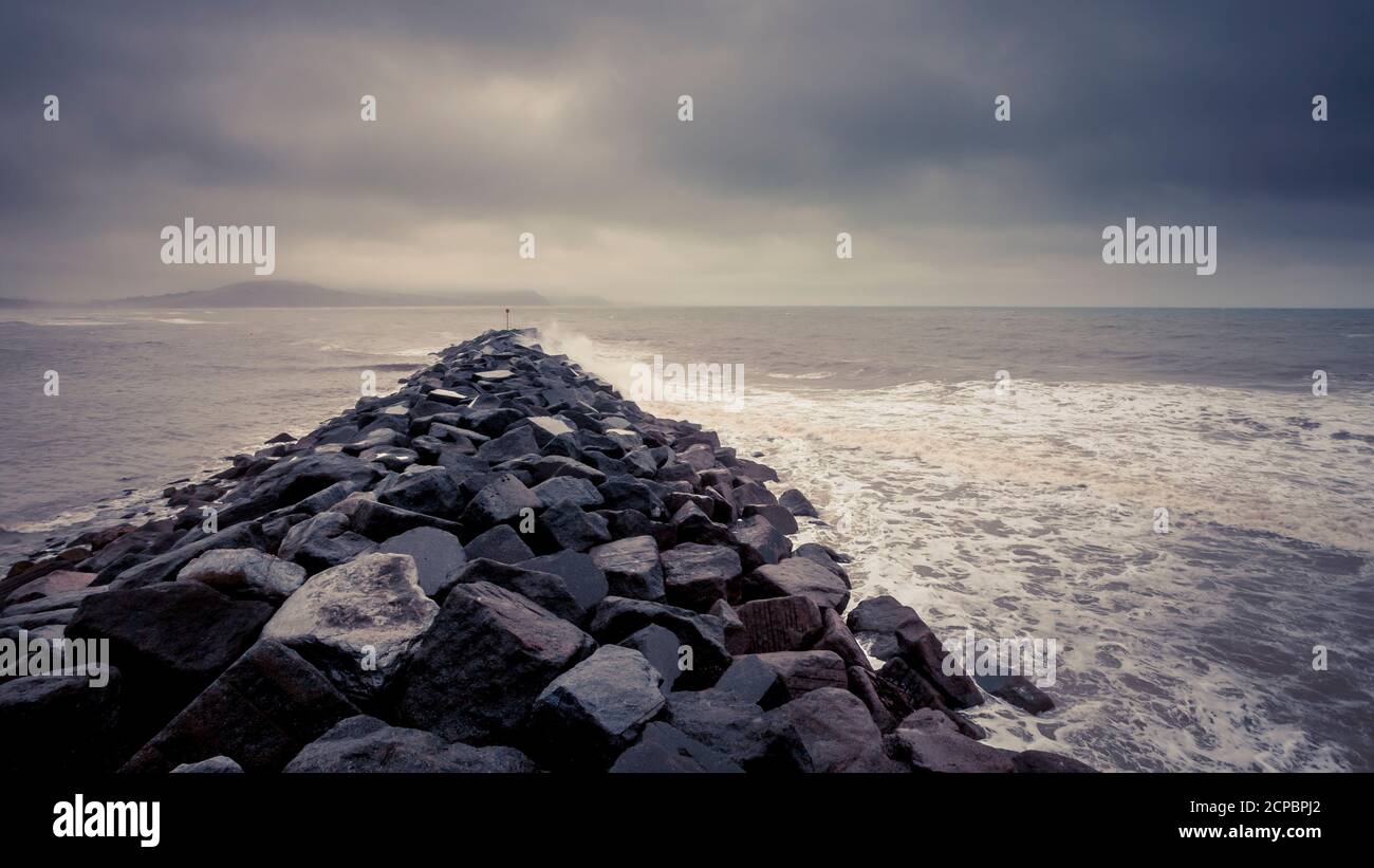 A breakwater of large rocks on a gloomy day Stock Photo - Alamy