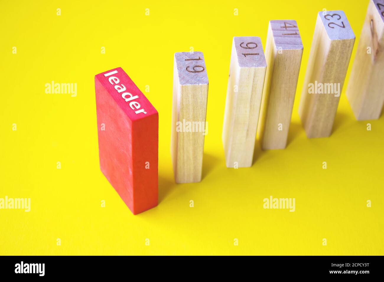 Red wooden block among the colorless on yellow background. Business ...