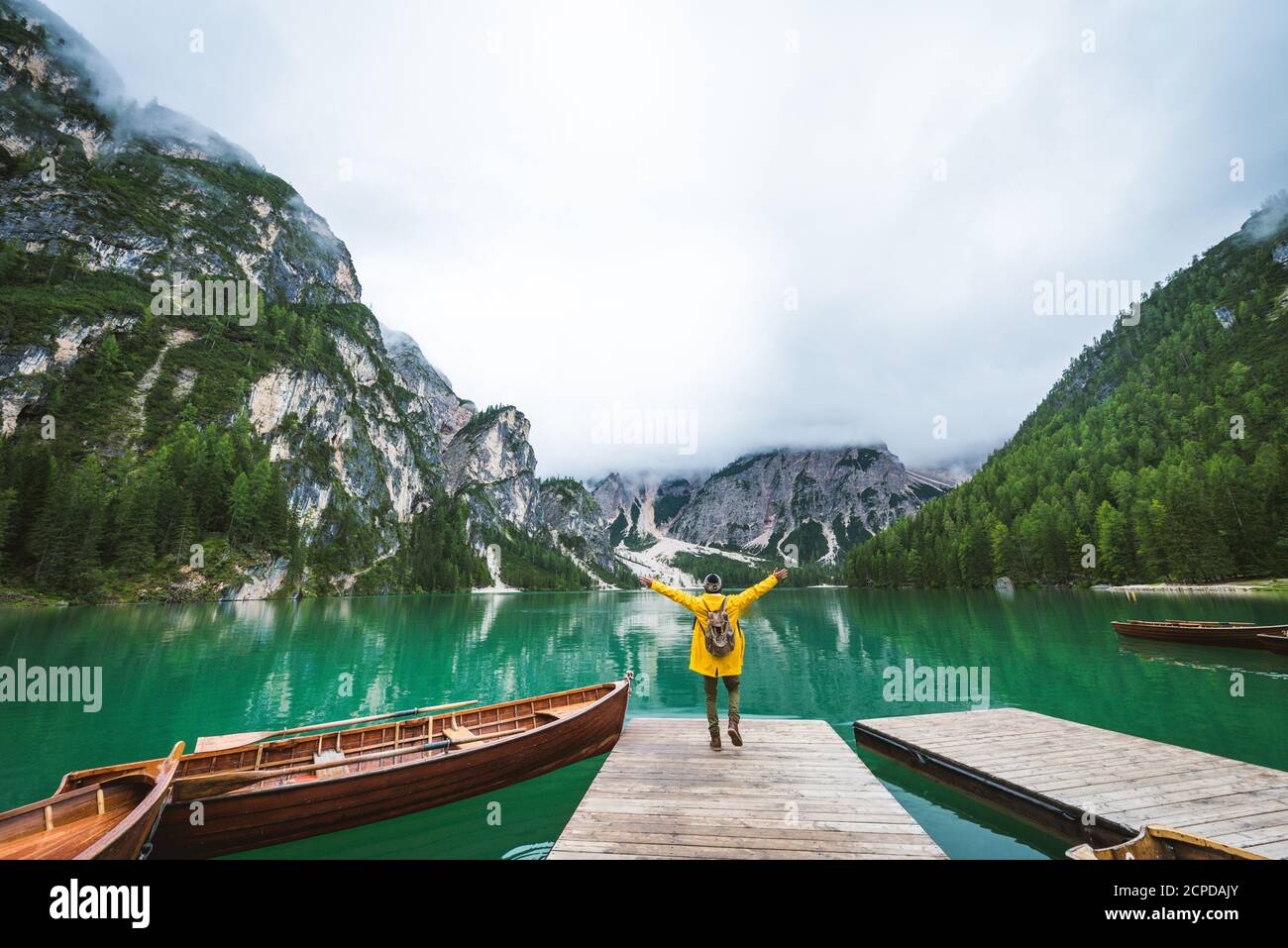 Traveler visiting an alpine lake at Braies, Italy - Tourist with hiking ...