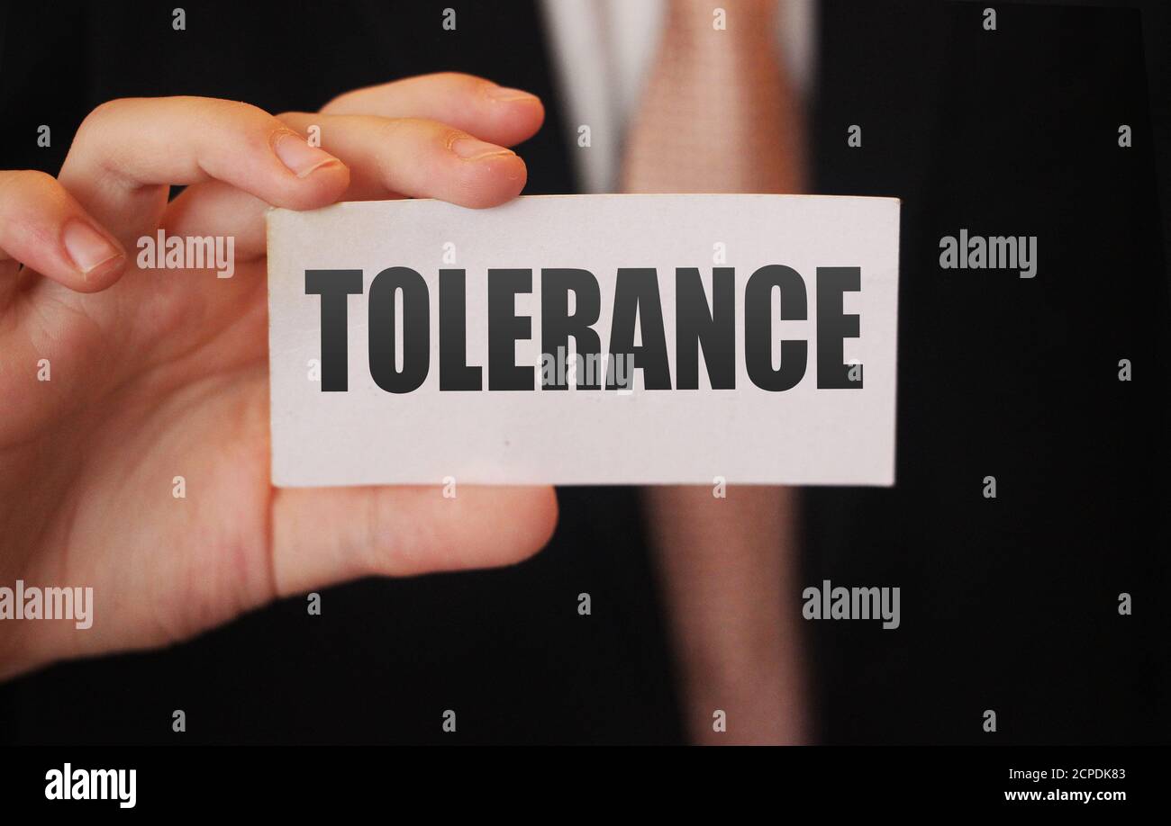 Tolerance words on a card in businessman hand. Social concept against ...