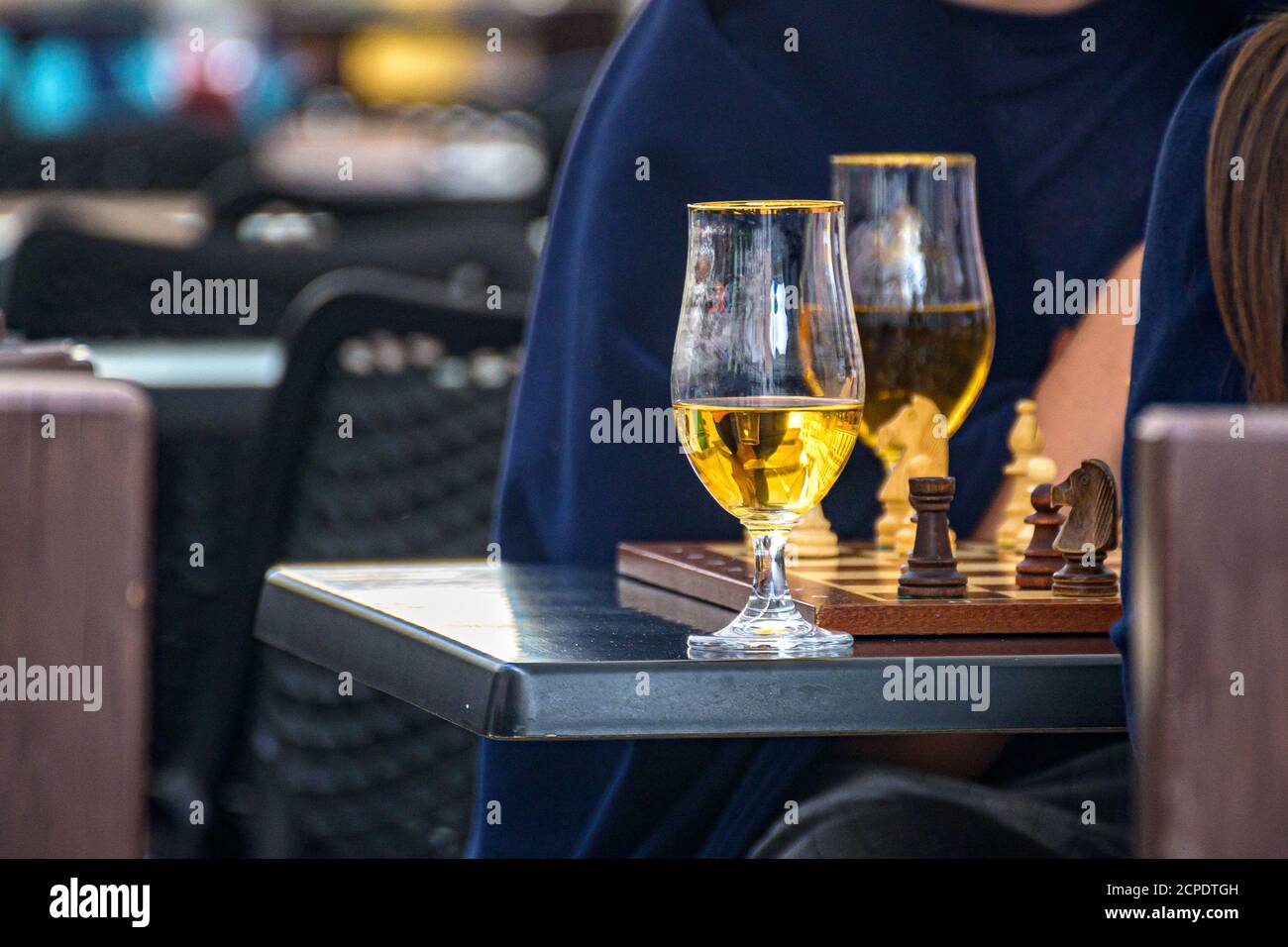 Visitors drink beer and play chess in a street cafe. Rest in a cafe ...