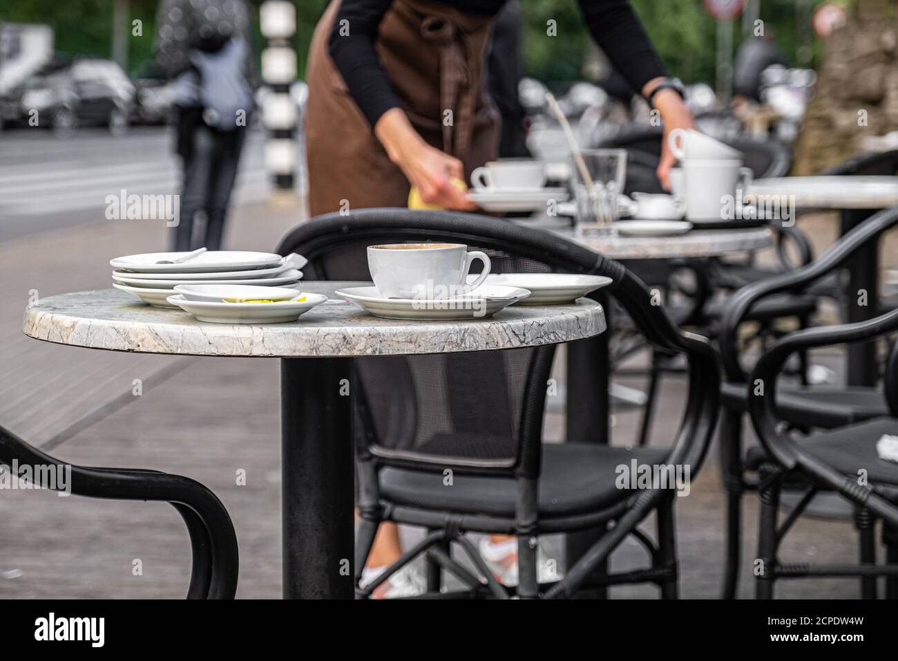 A table with uncleared dishes after visitors in a street cafe with a ...