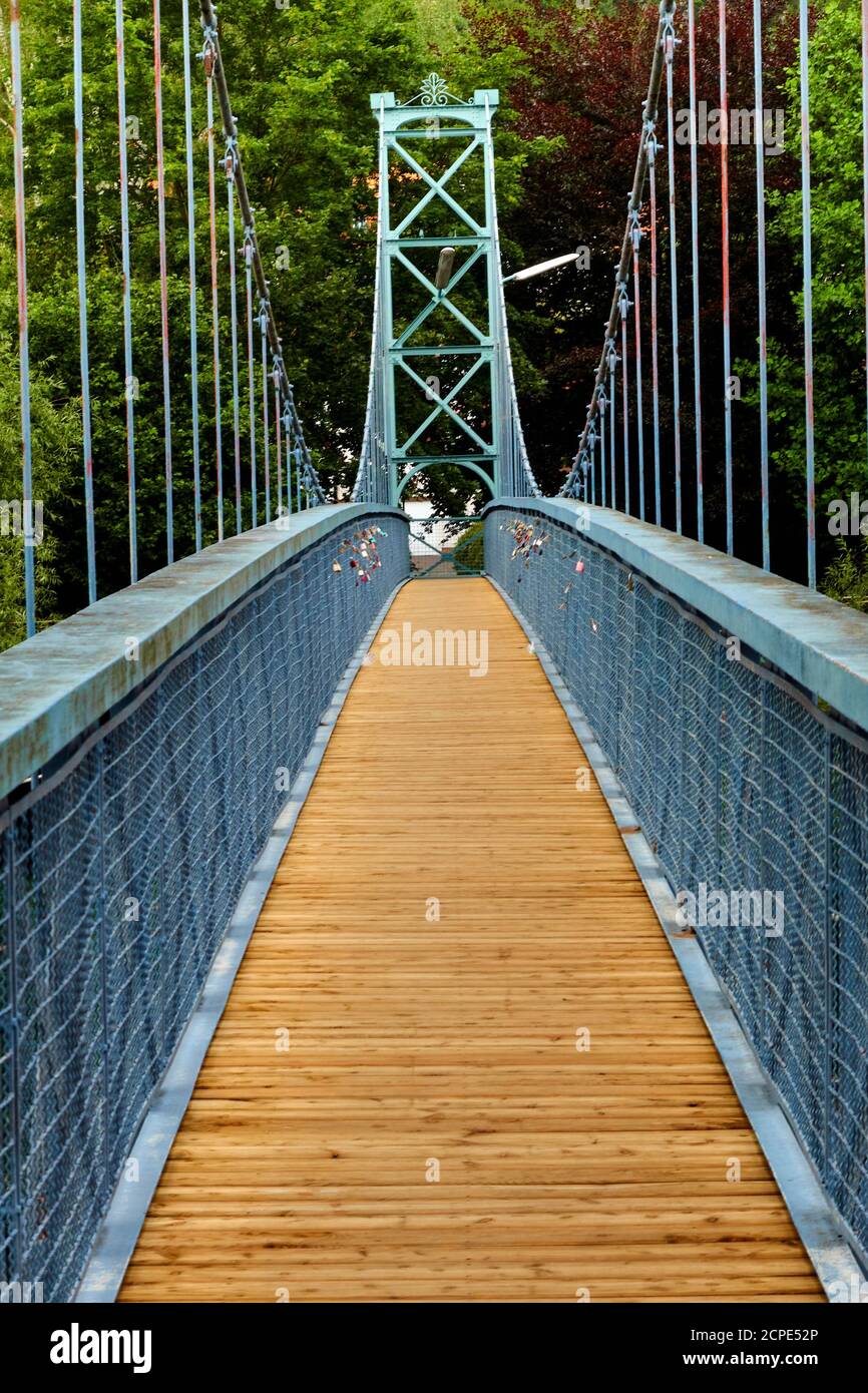 Vertical shot of suspension bridge surrounded by greenery Stock Photo ...