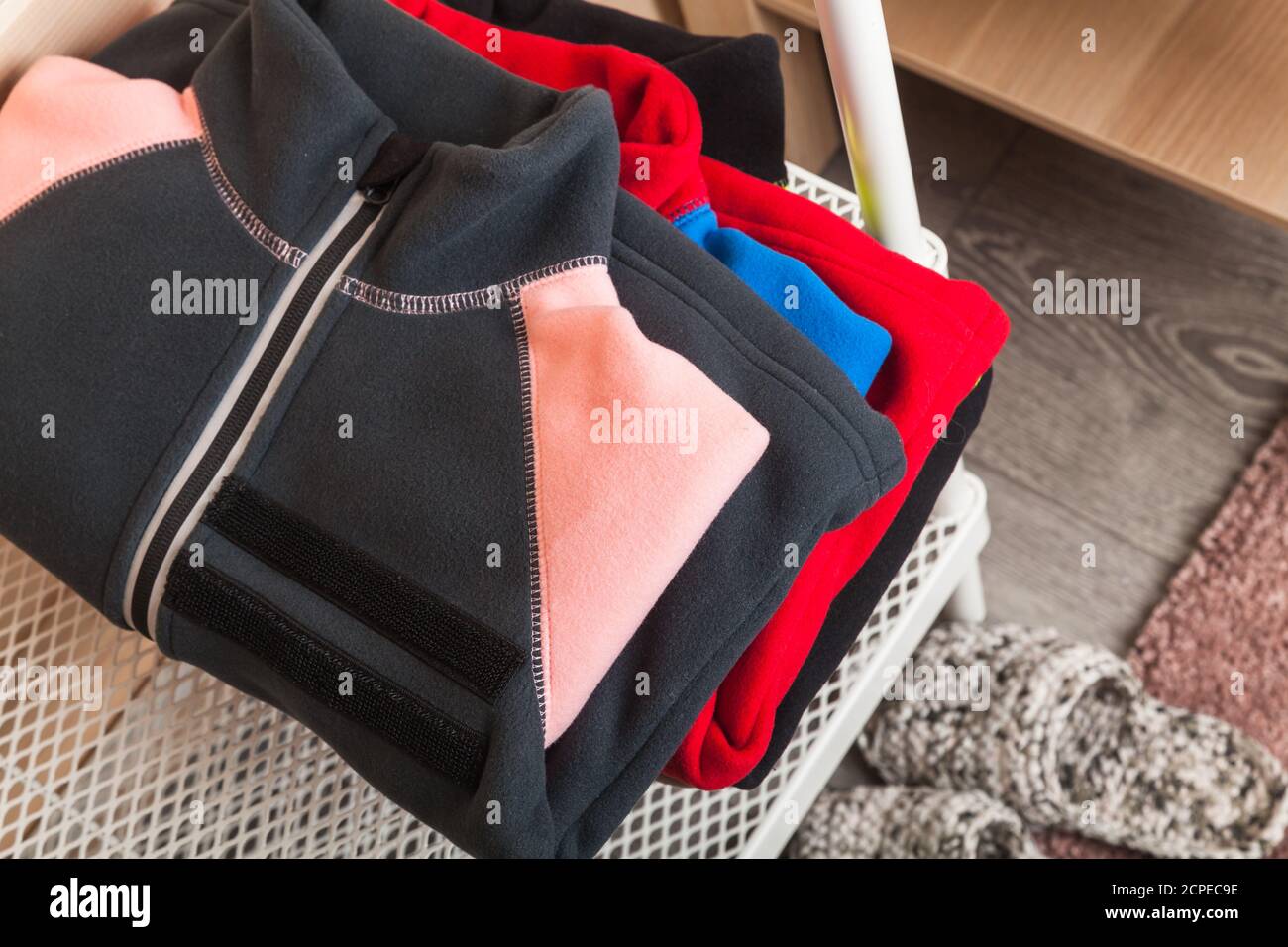 Stacked colorful fleece jackets laying on a white shelf Stock Photo - Alamy