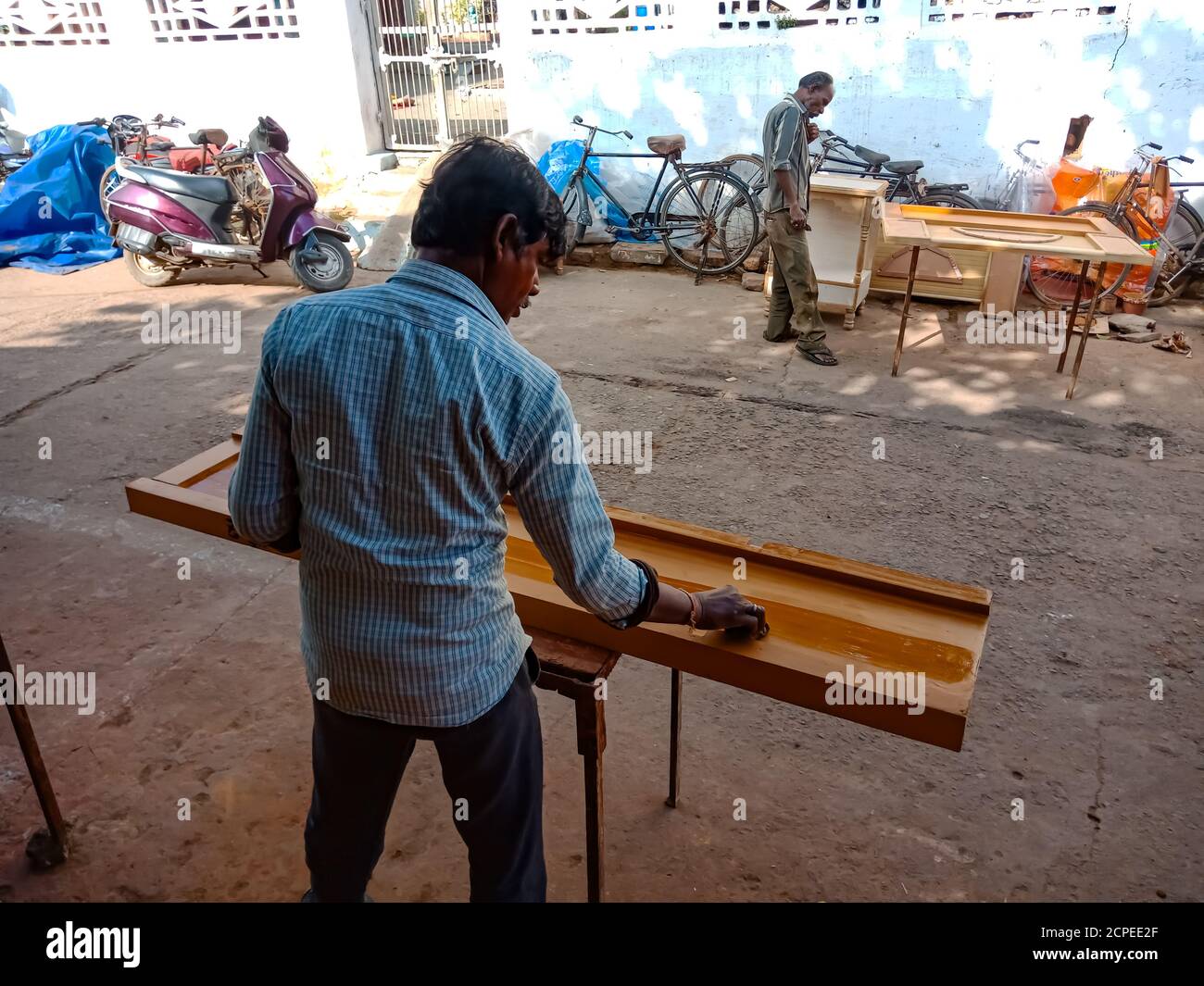 DISTRICT KATNI, INDIA - JANUARY 08, 2020: An indian woodworker applying ...