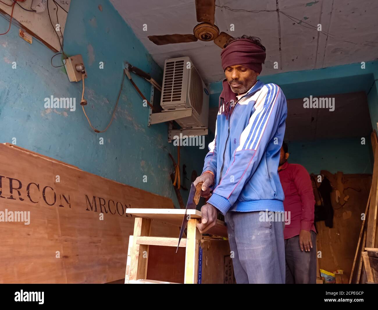 DISTRICT KATNI, INDIA - JANUARY 08, 2020: An indian woodworker chopping ...
