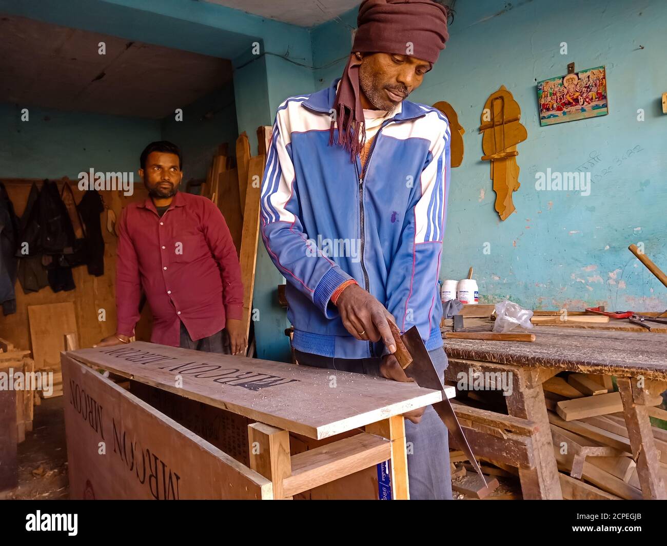 DISTRICT KATNI, INDIA - JANUARY 08, 2020: An asian woodworker chopping ...