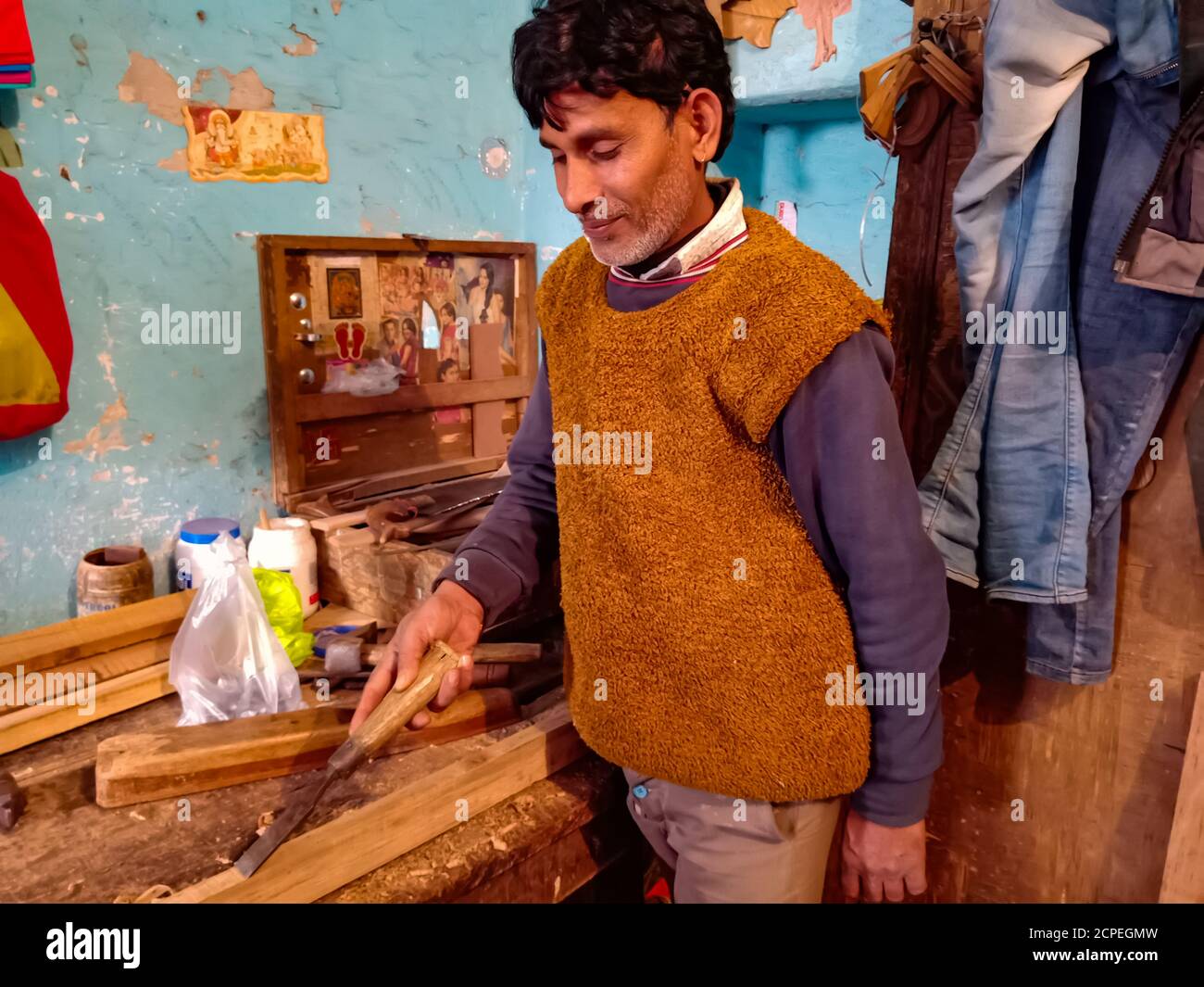 DISTRICT KATNI, INDIA - JANUARY 08, 2020: An asian woodworker slicing ...
