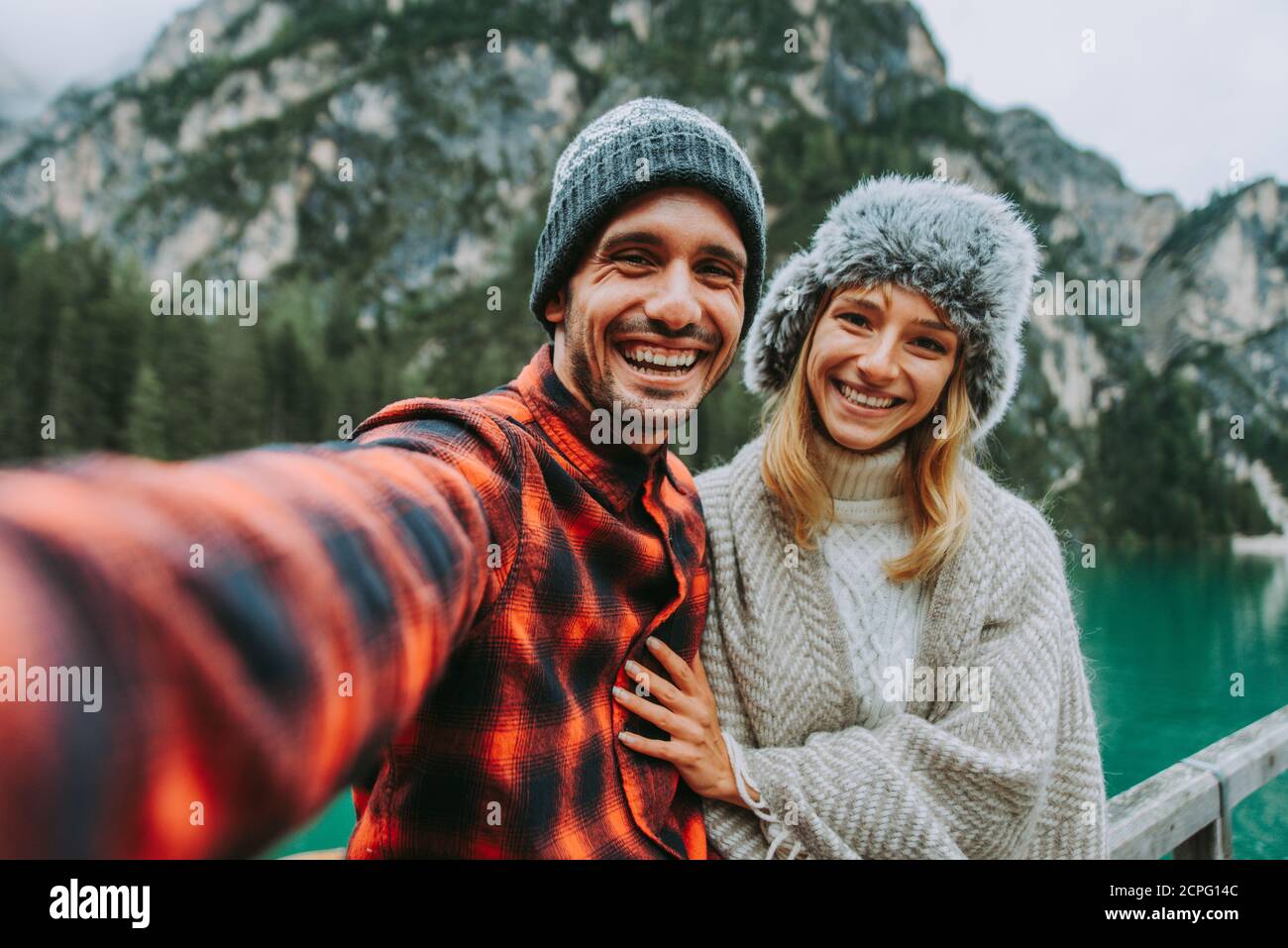Beautiful couple of young adults visiting an alpine lake at Braies ...