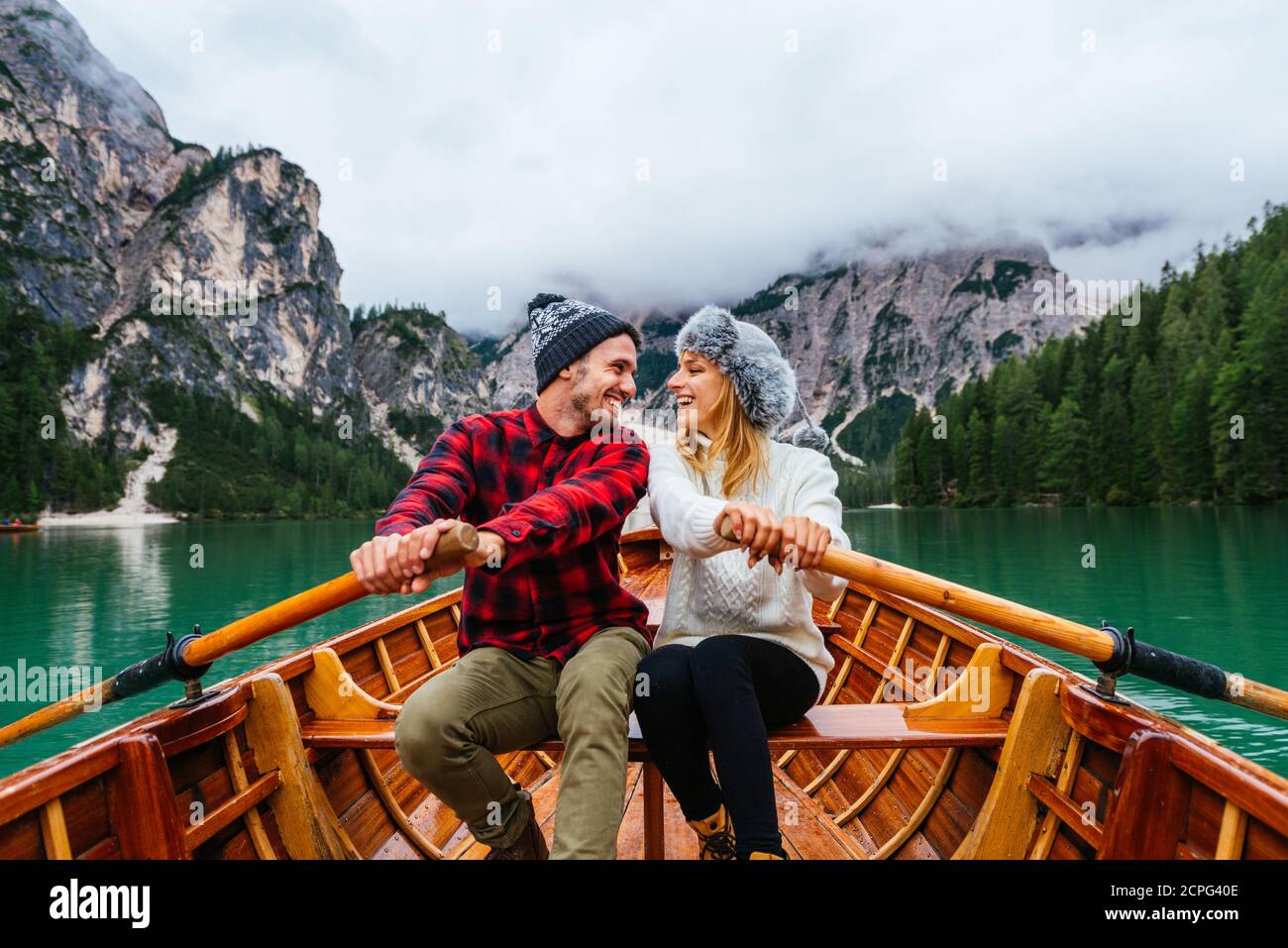 Beautiful couple of young adults visiting an alpine lake at Braies ...