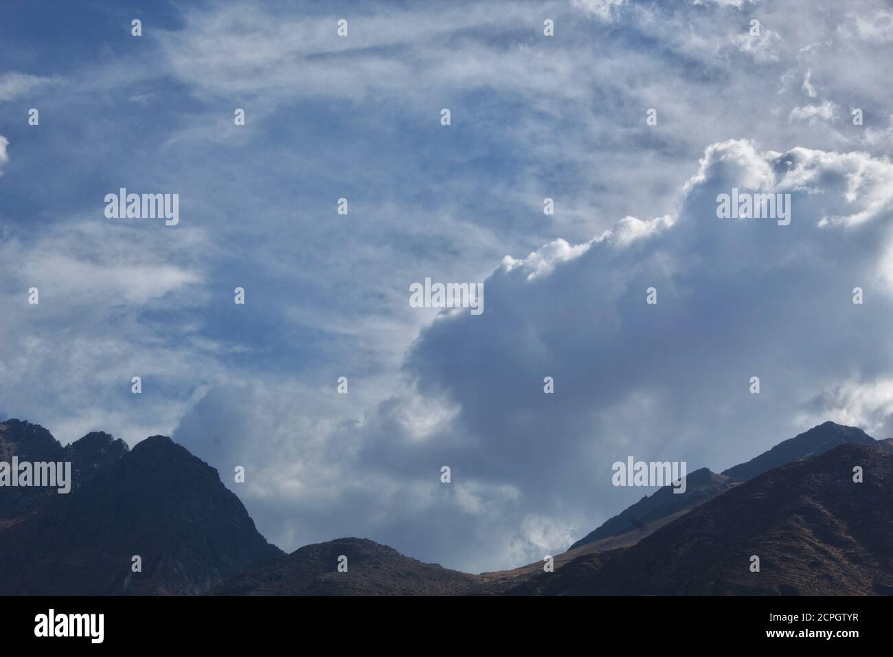 Mountains gleaming under the fluffy cloudy sky Stock Photo - Alamy