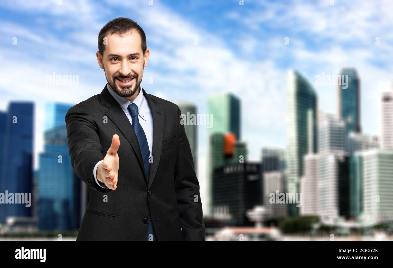 Handsome businessman offering handshake in an urban setting Stock Photo ...