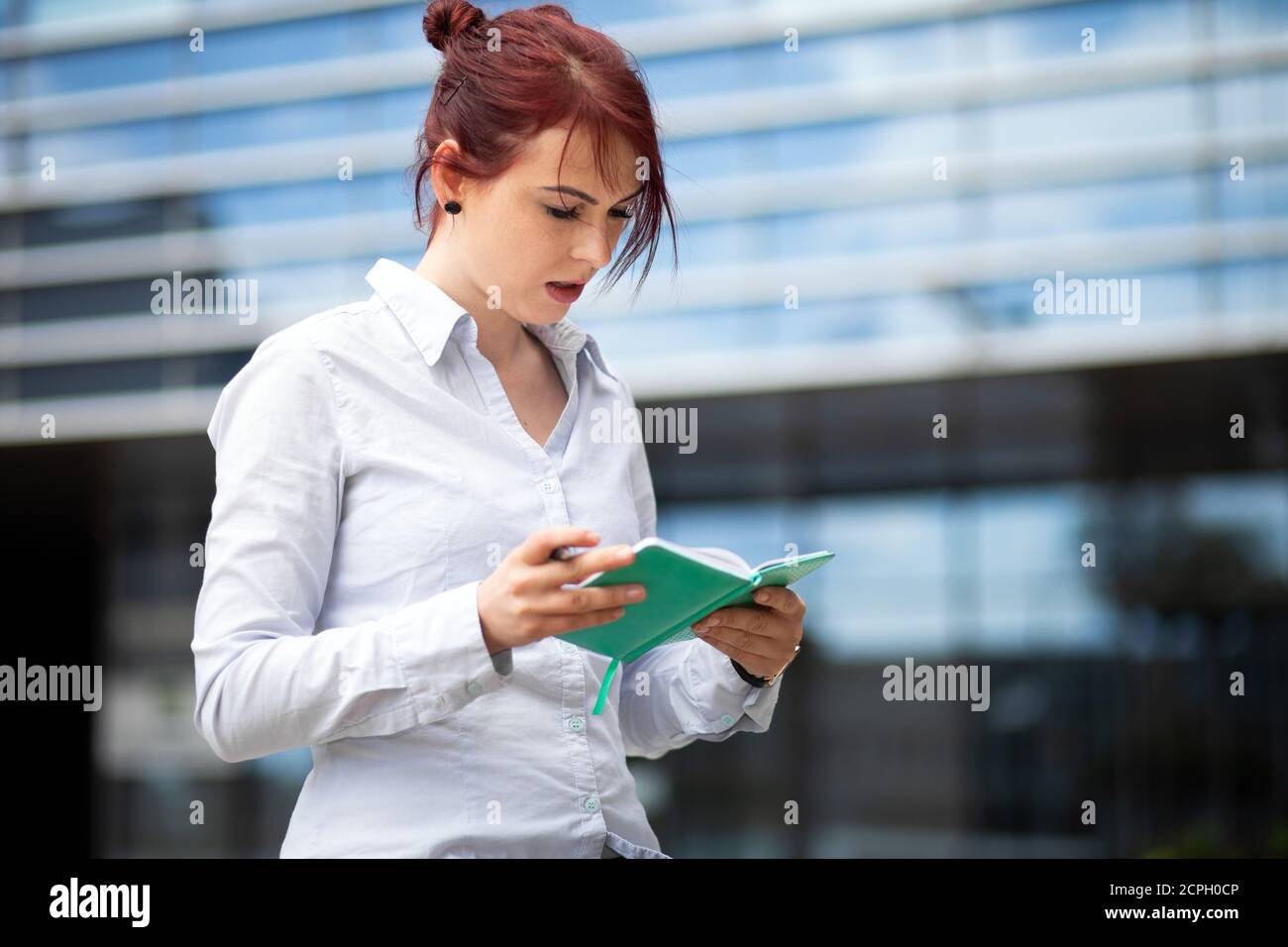 Young secretaryYoung secretary reading her agenda outdoor Stock Photo ...