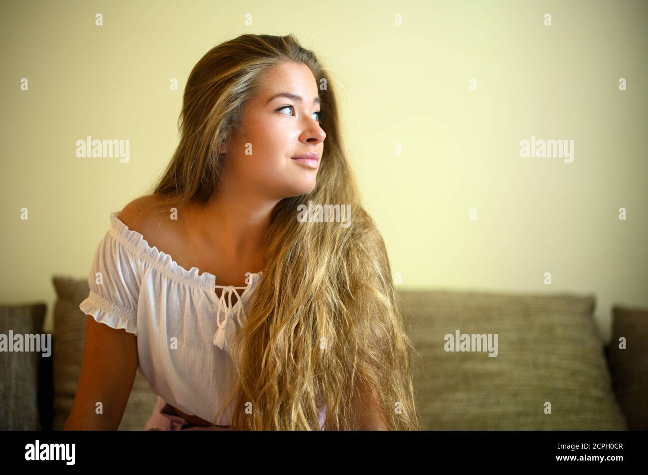 Young woman on sofa with thoughtful look hi-res stock photography and ...