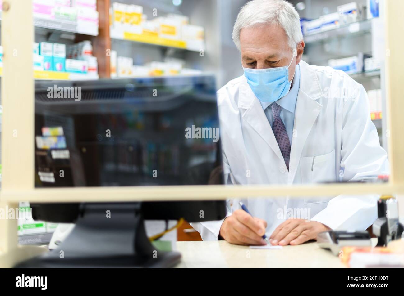 Pharmacist at work with a computer in his store Stock Photo - Alamy