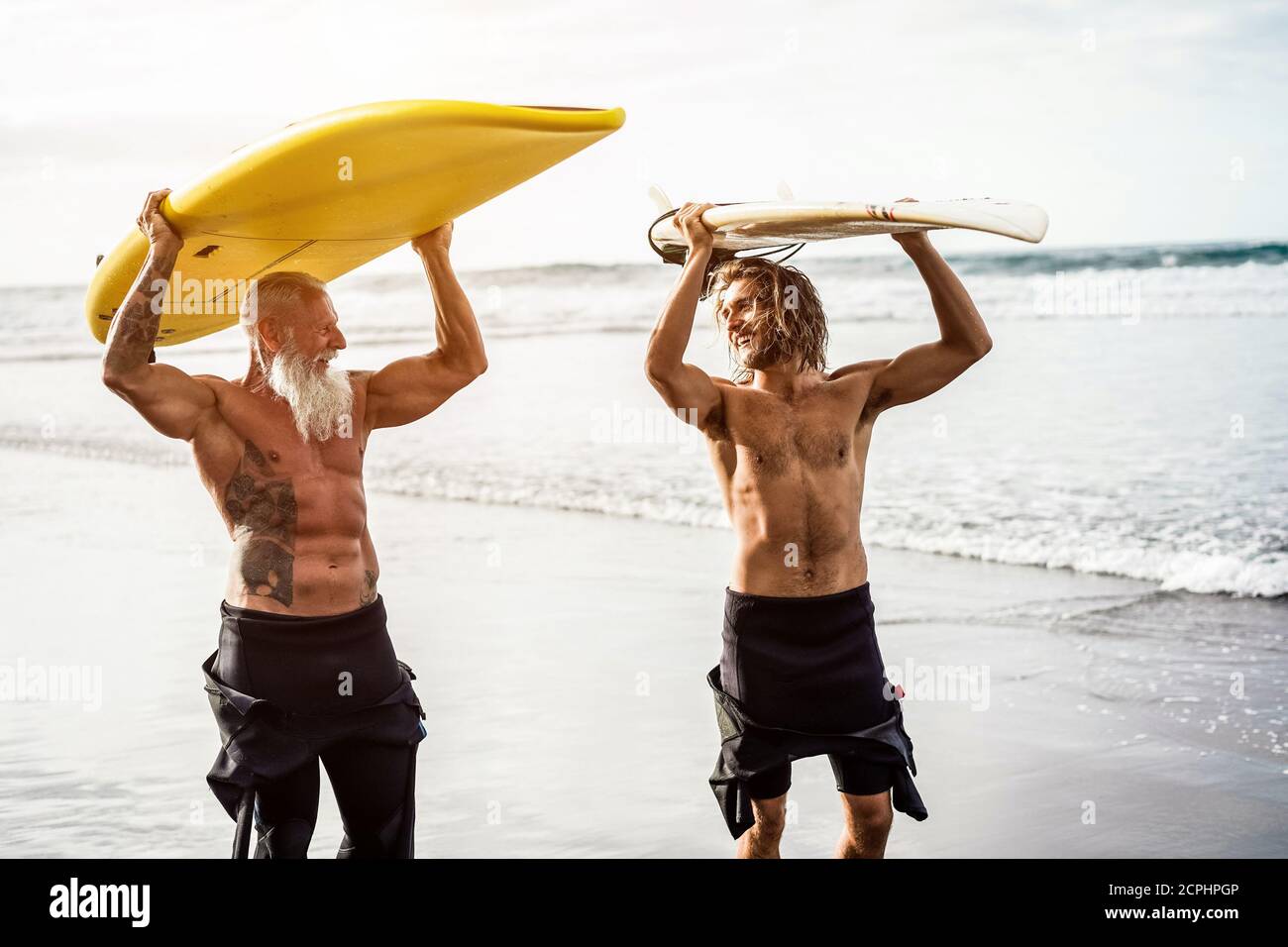 Multigeneration friends going to surf on tropical beach - Family people ...