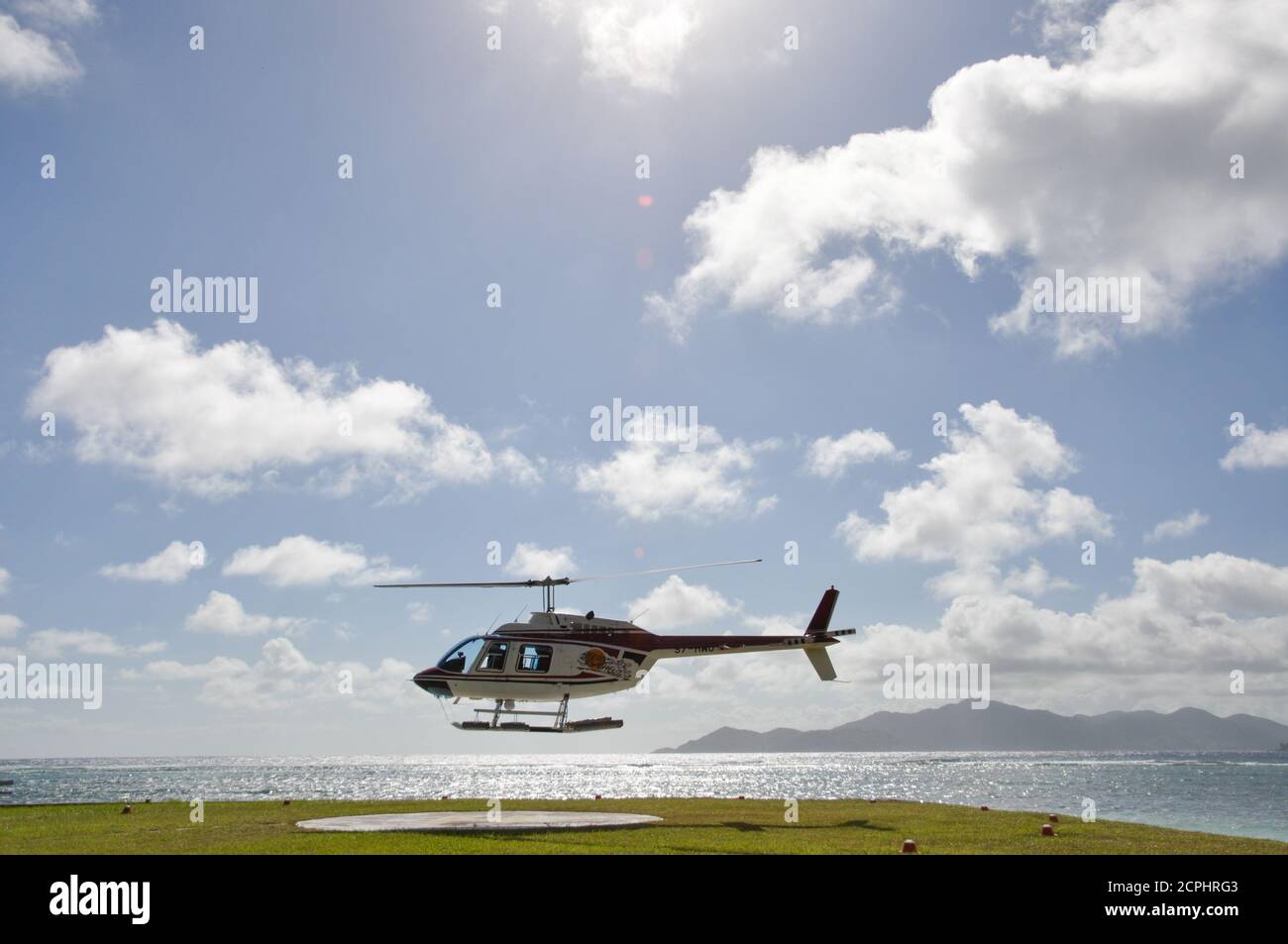 Helicopter landing on a helipad on a tropical island Stock Photo - Alamy