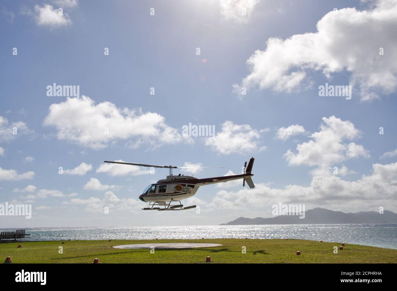 Helicopter landing on a helipad on a tropical island Stock Photo - Alamy