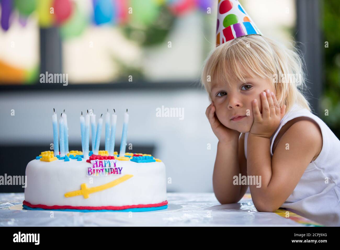 Adorable happy child, little kid boy celebrating his birthday at home ...
