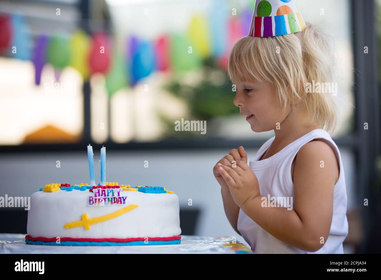 Adorable happy child, little kid boy celebrating his birthday at home ...