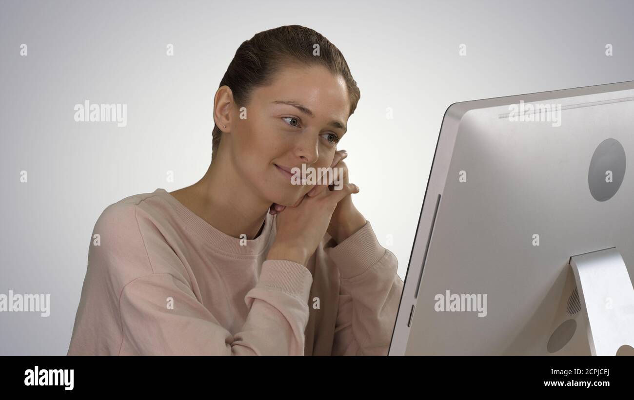 Blonde girl with pink pullover looking at monitor of computer wa Stock ...